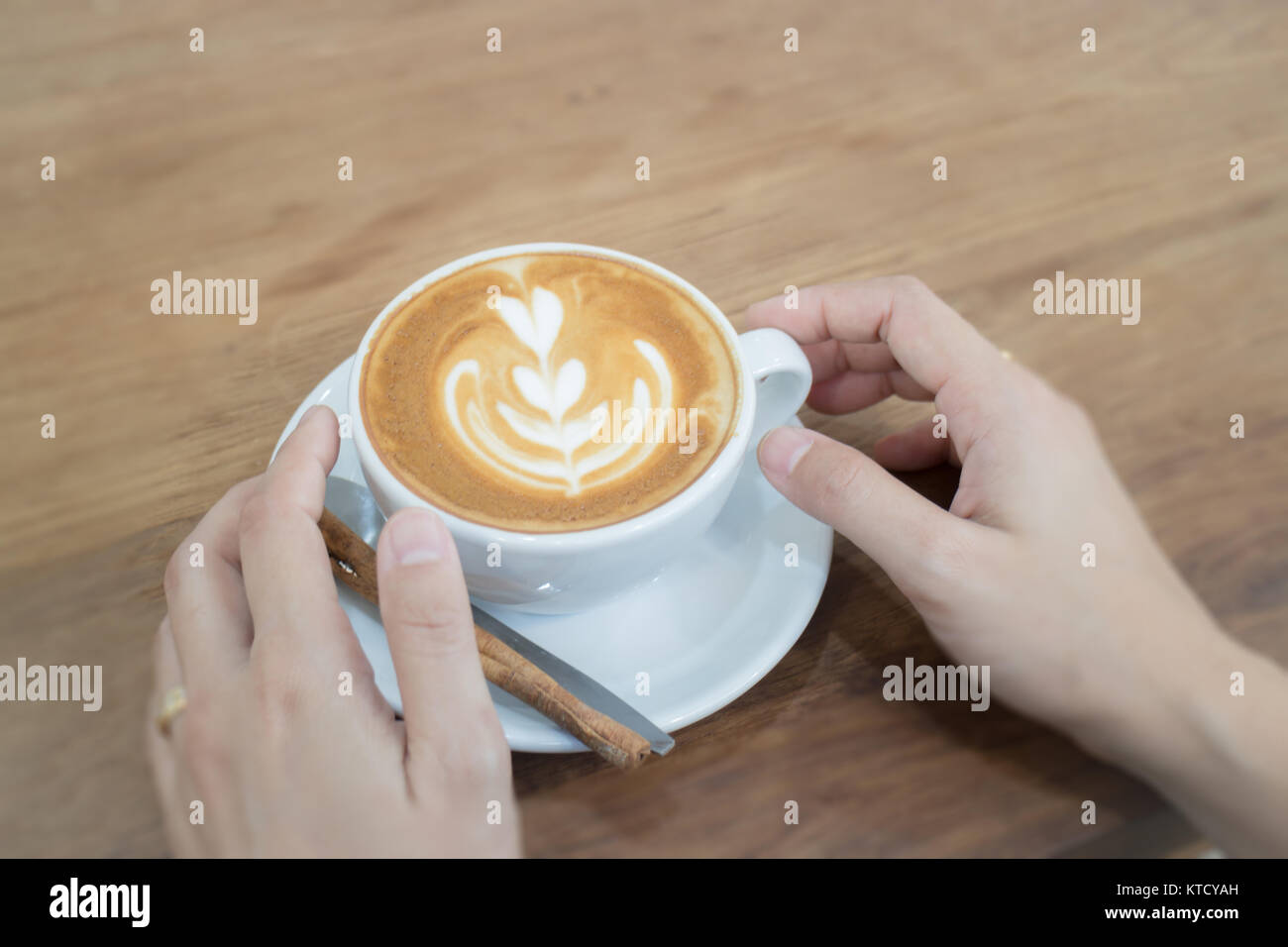 Hand On Hot Cup Of Coffee Latte Stock Photo - Alamy