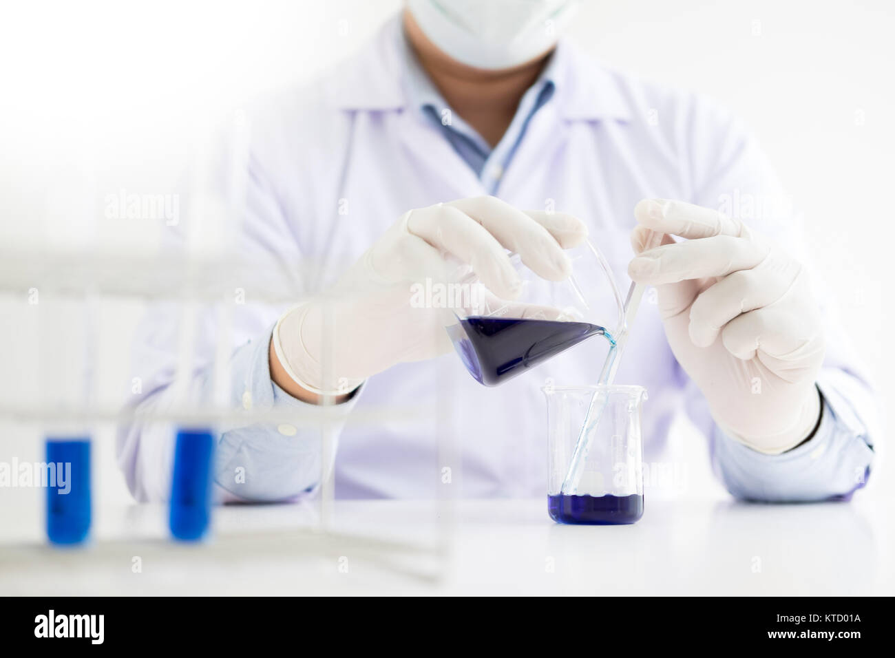 scientists and scientific equipment Pouring mixing reagents liqiud ...