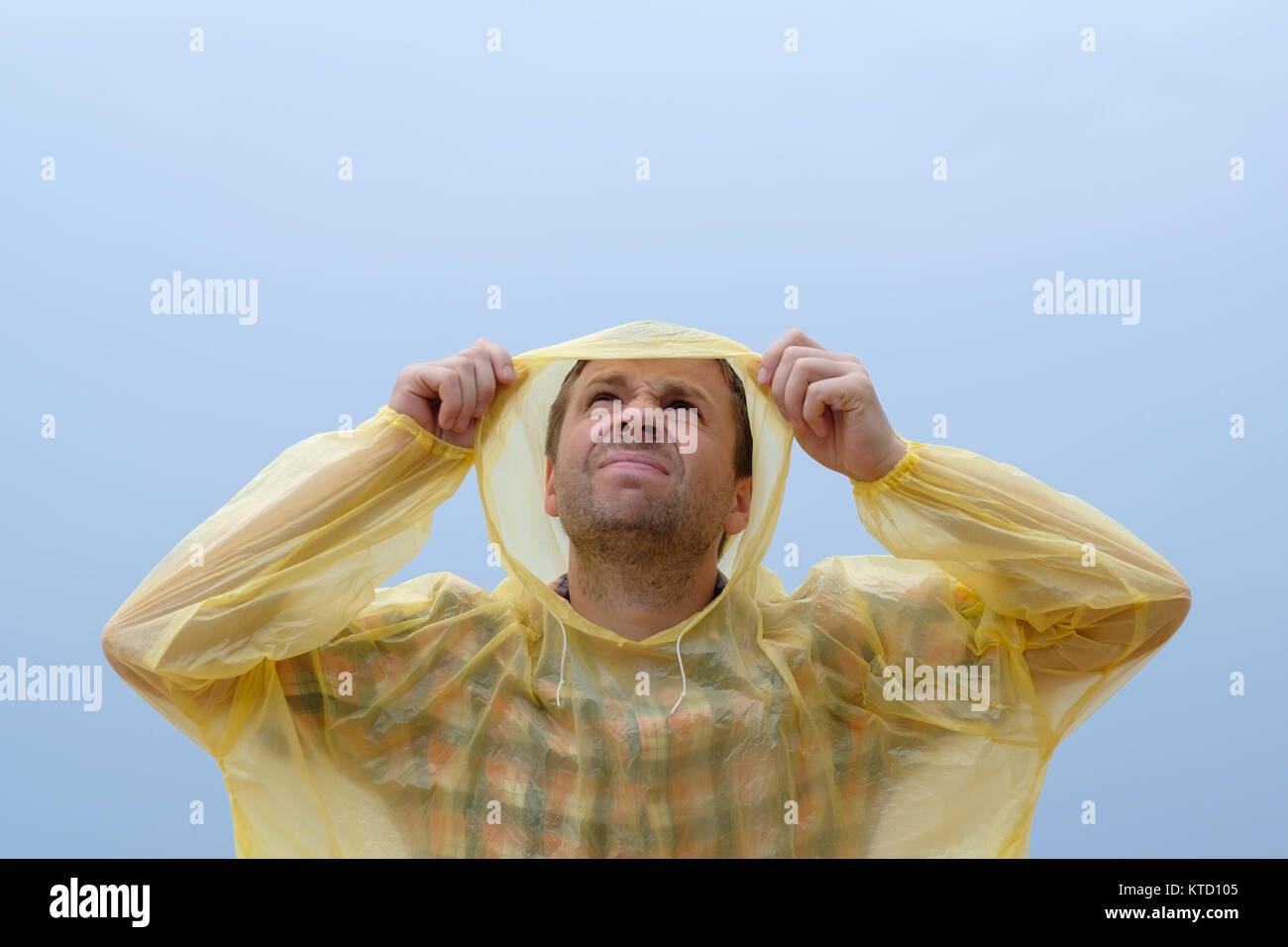 Young caucasian man getting wet under the rain during storm. He stands ...