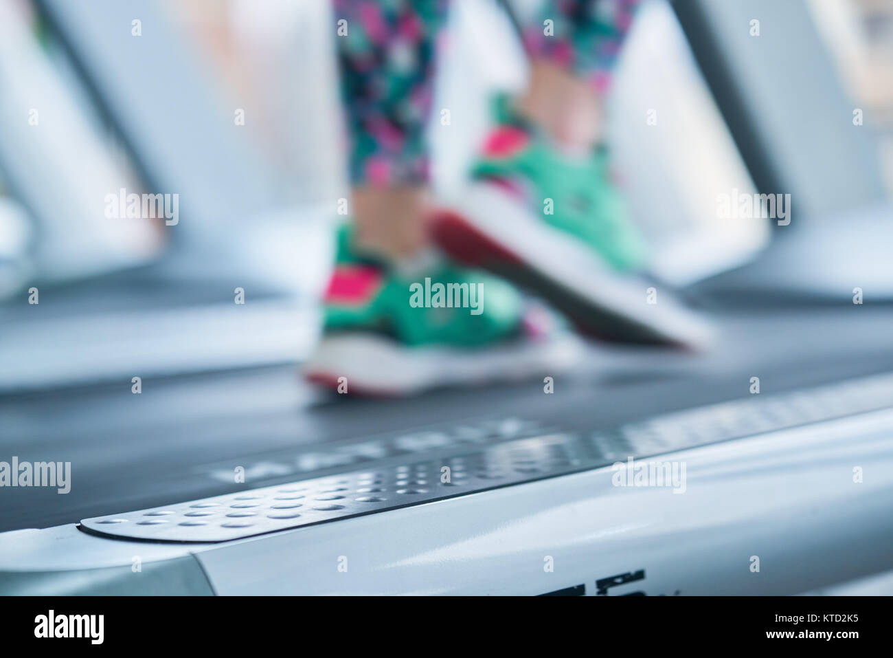 Female muscular feet in sneakers running on the treadmill at the gym ...