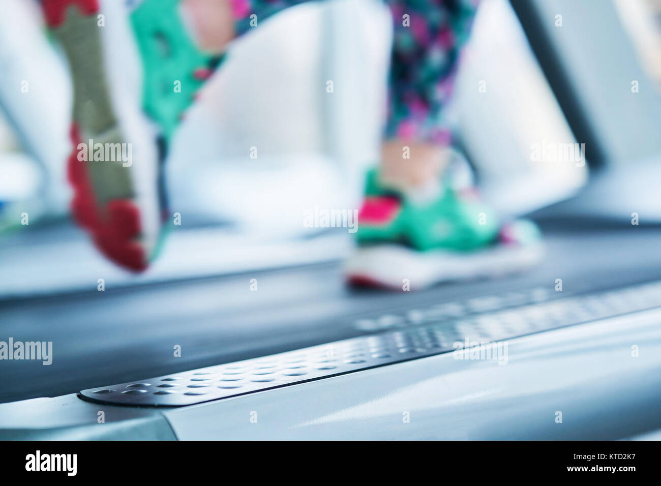 Female muscular feet in sneakers running on the treadmill at the gym ...