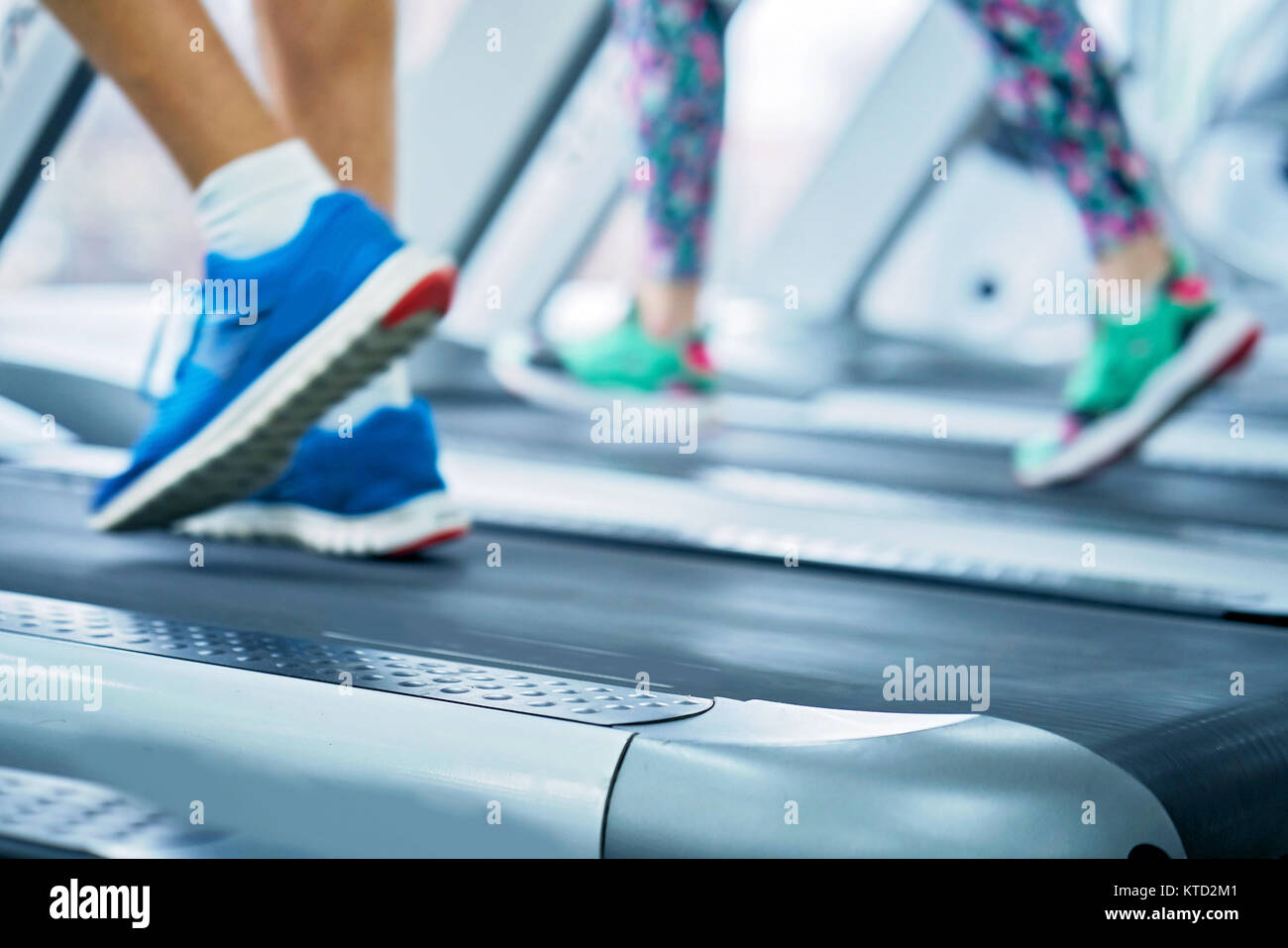 Female muscular feet in sneakers running on the treadmill at the gym ...