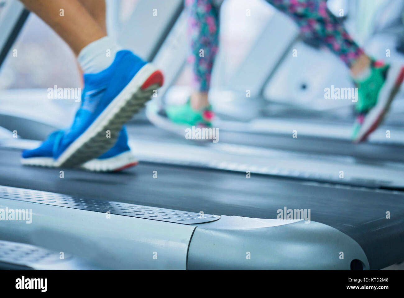Female muscular feet in sneakers running on the treadmill at the gym ...