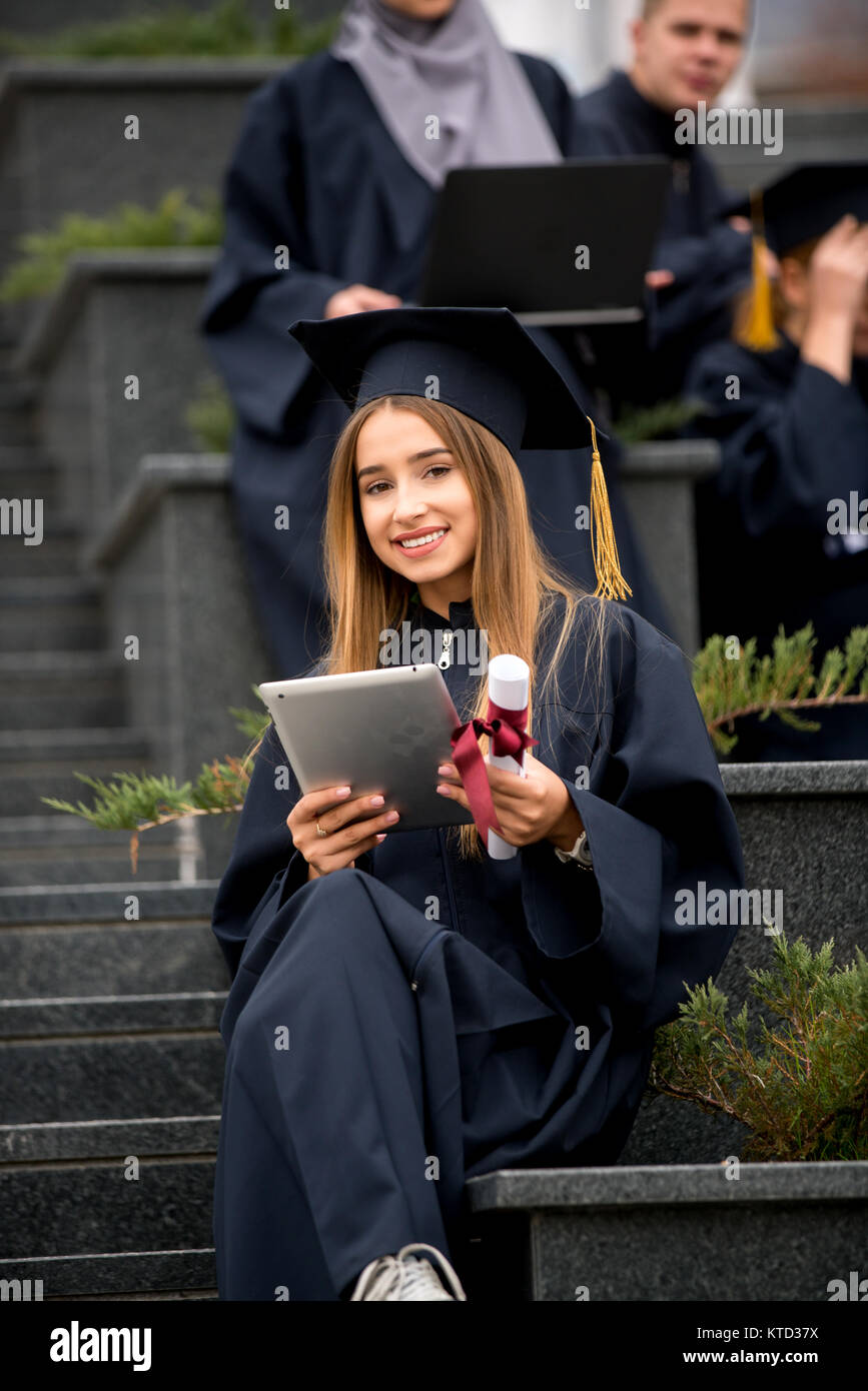 Pretty young graduate with collegues, teamwork, diploma Stock Photo - Alamy