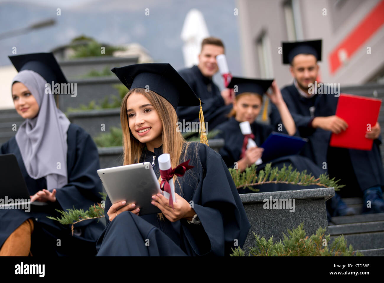 Pretty young graduate with collegues, teamwork, diploma Stock Photo - Alamy