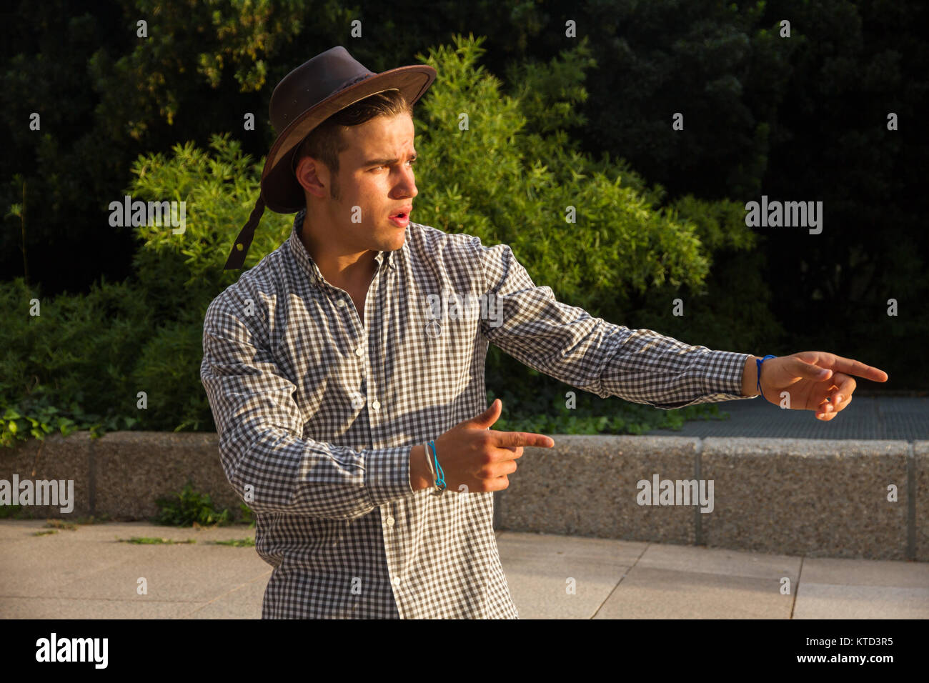 Strong and muscular young man posing on the street. He wears a shirt ...