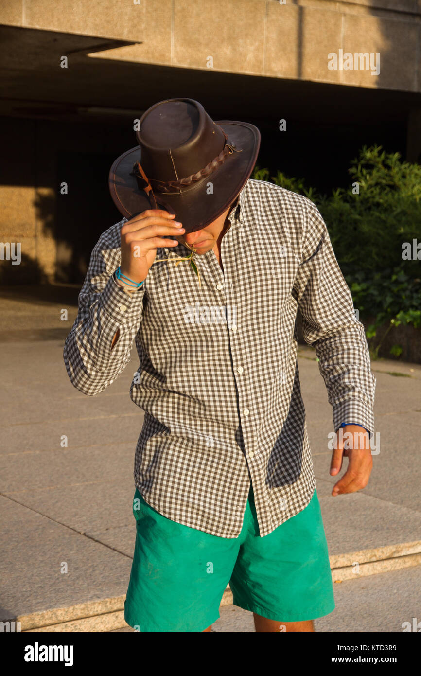 Strong and muscular young man posing on the street. He wears a shirt ...