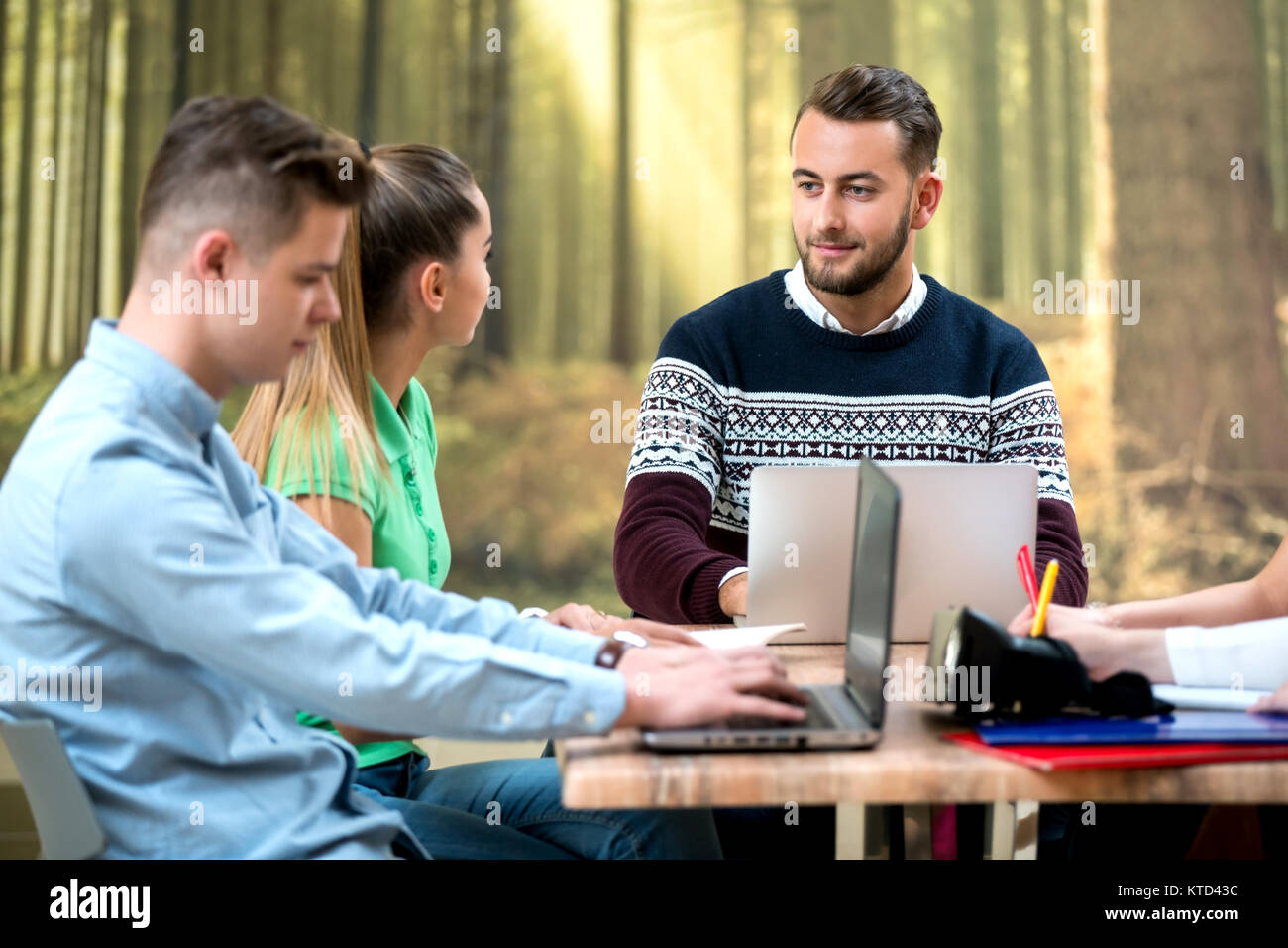 Multi ethnic group of students working on task together. Teamwork ...