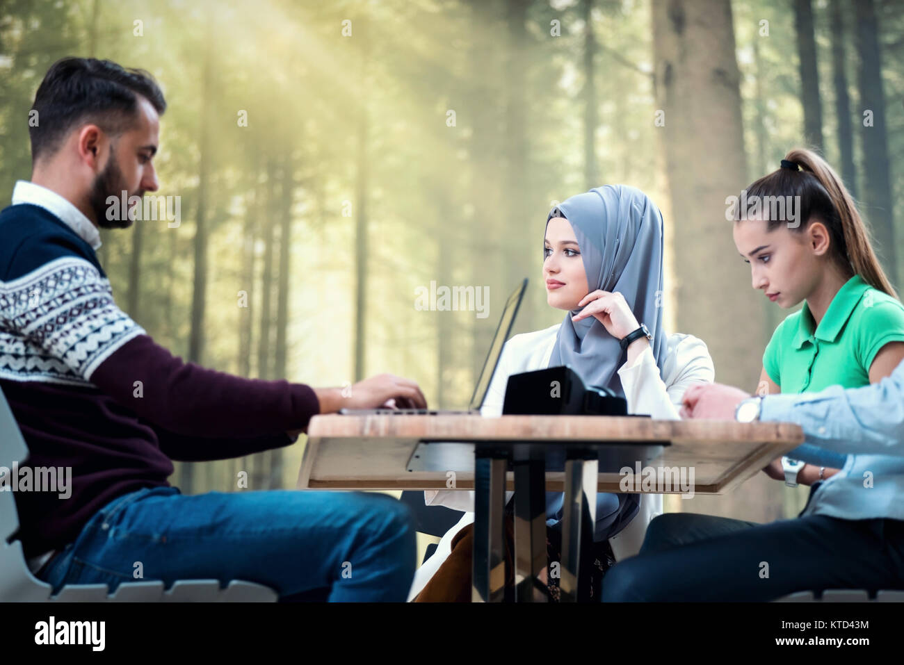 Multi ethnic group of students working on task together. Teamwork ...