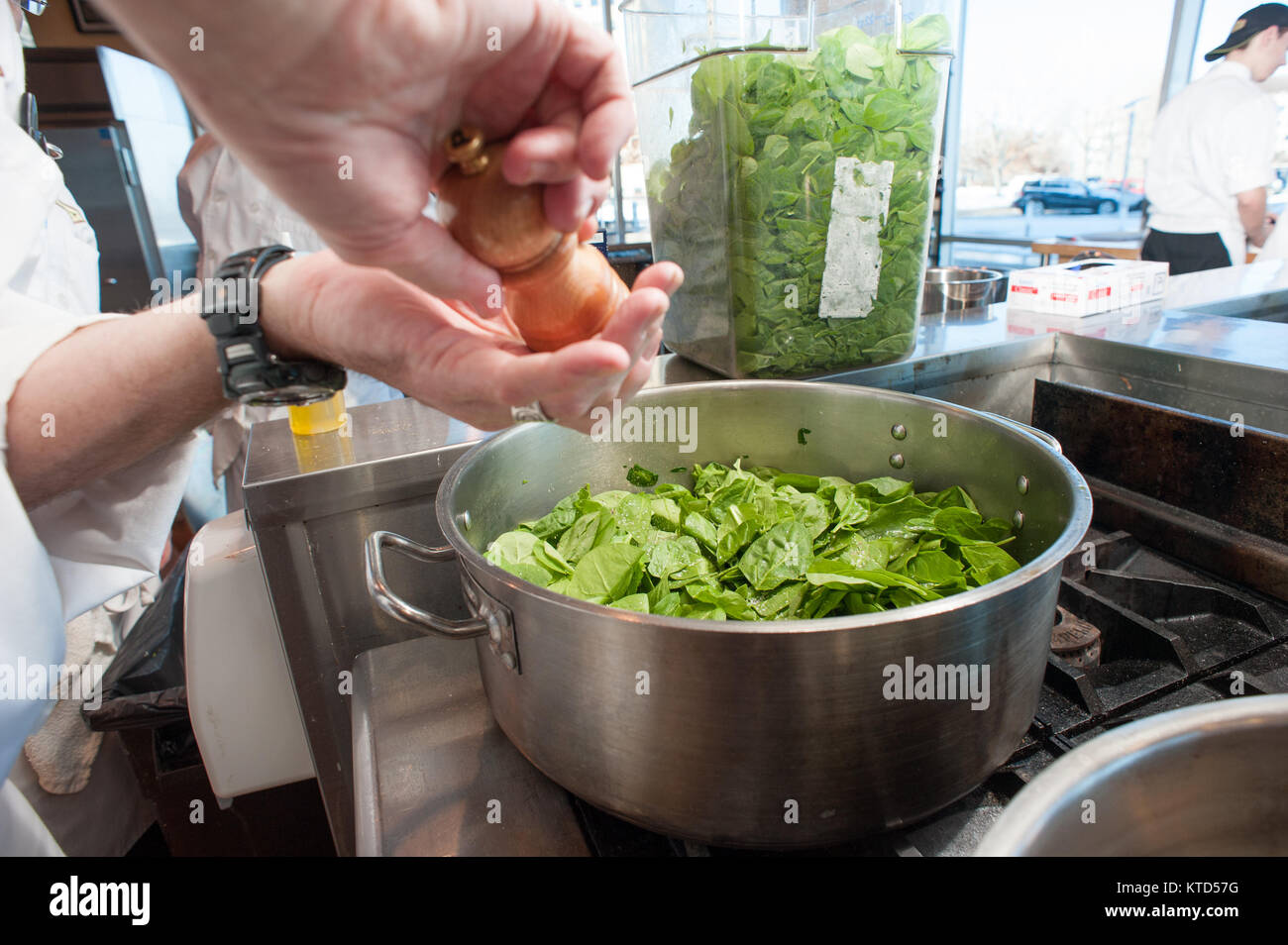 Spinach in a pan being seasoned Stock Photo - Alamy