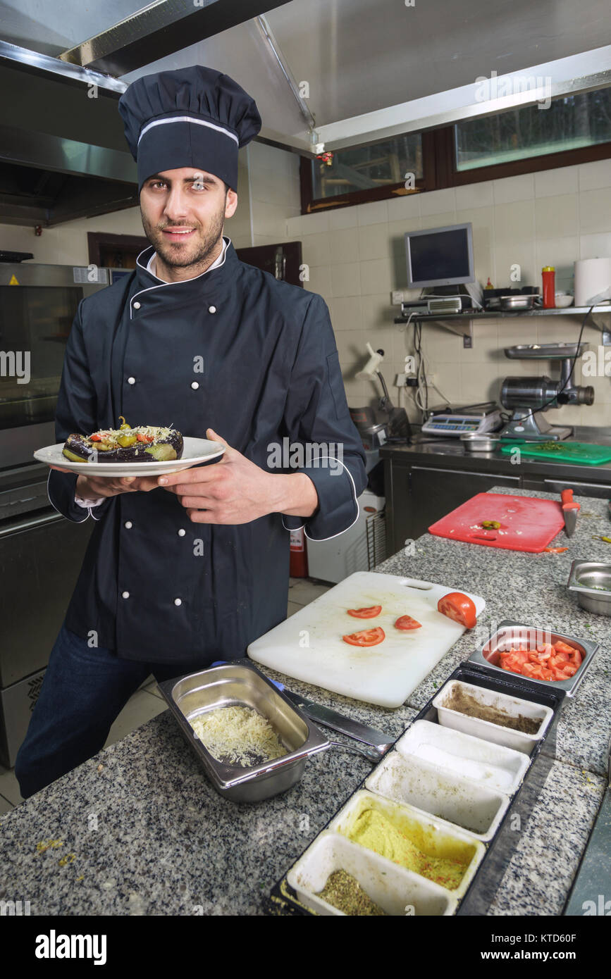 Chef in Restaurant garnishing vegetable dish, crop on hands, filtered ...