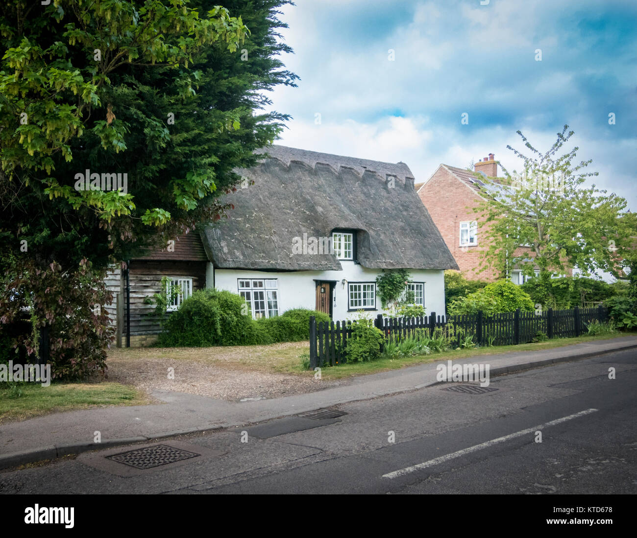 Street view of an old thatched cottage in the pretty village of Foxton ...
