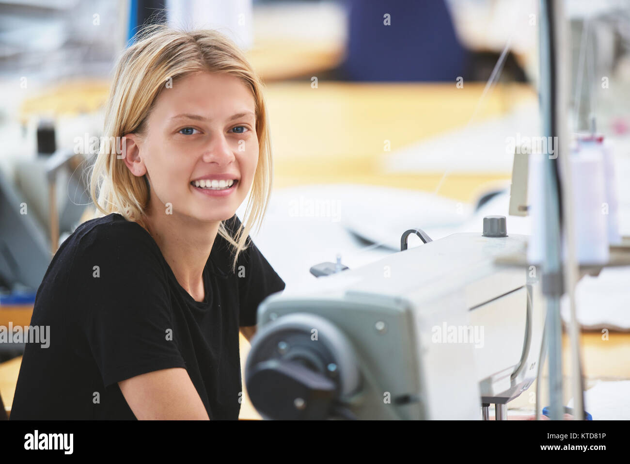 Seamstress or worker in a factory sewing with a industrial sewing ...
