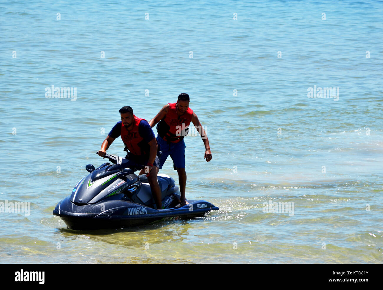 Two men getting off a jet ski Stock Photo - Alamy