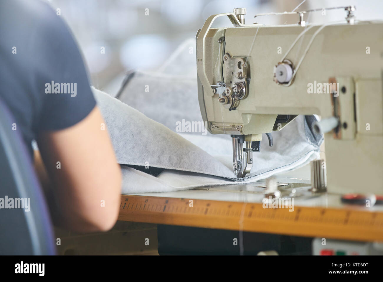 Seamstress or worker in a factory sewing with a industrial sewing ...