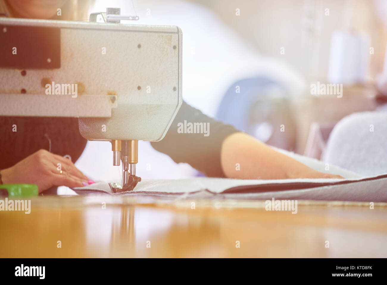 Seamstress or worker in a factory sewing with a industrial sewing ...