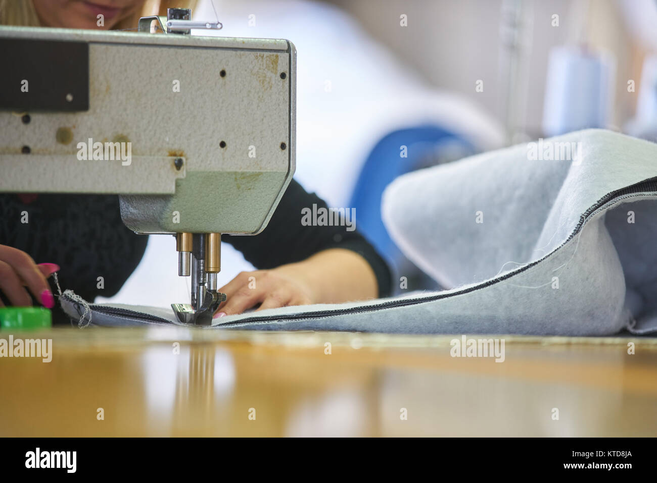 Seamstress or worker in a factory sewing with a industrial sewing ...