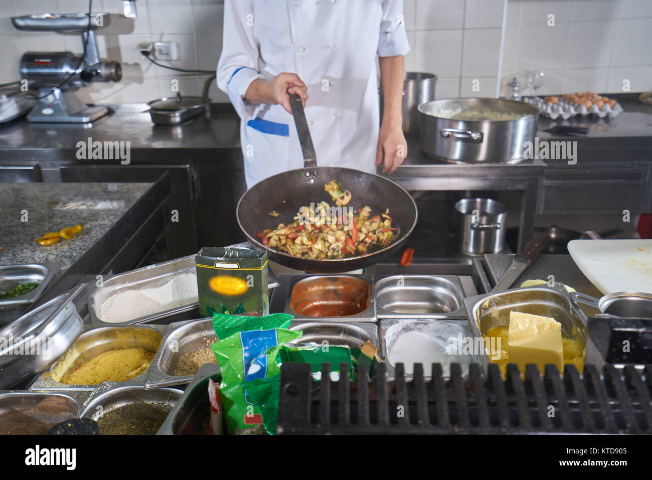 Chef sprinkling spices on dish in commercial kitchen Stock Photo - Alamy
