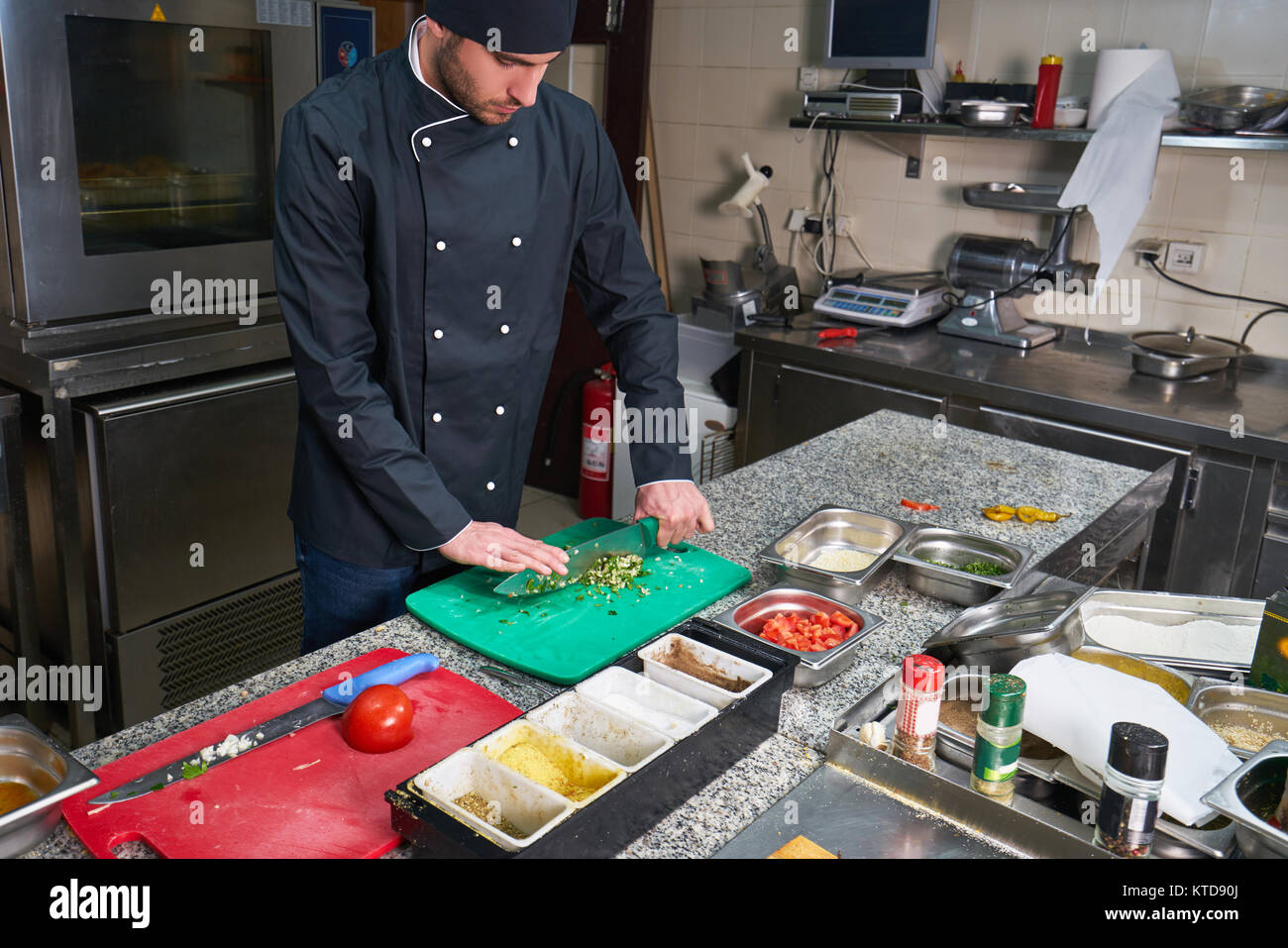 Chef sprinkling spices on dish in commercial kitchen Stock Photo - Alamy