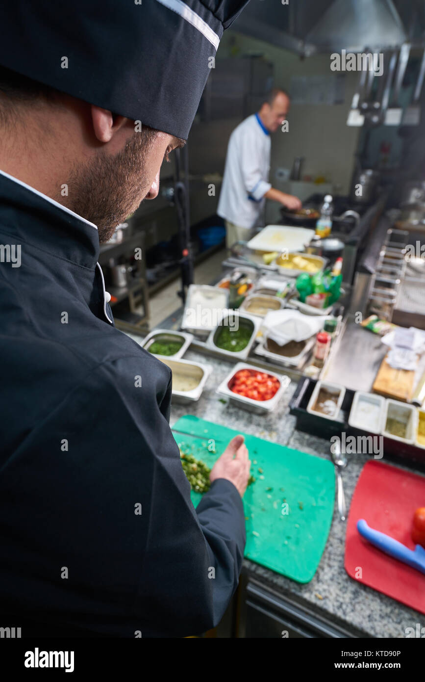 Chef sprinkling spices on dish in commercial kitchen Stock Photo - Alamy