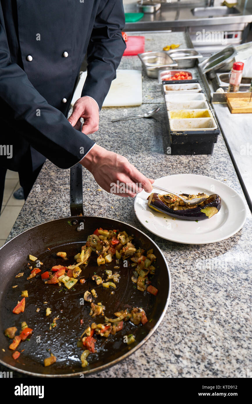 Chef sprinkling spices on dish in commercial kitchen Stock Photo - Alamy