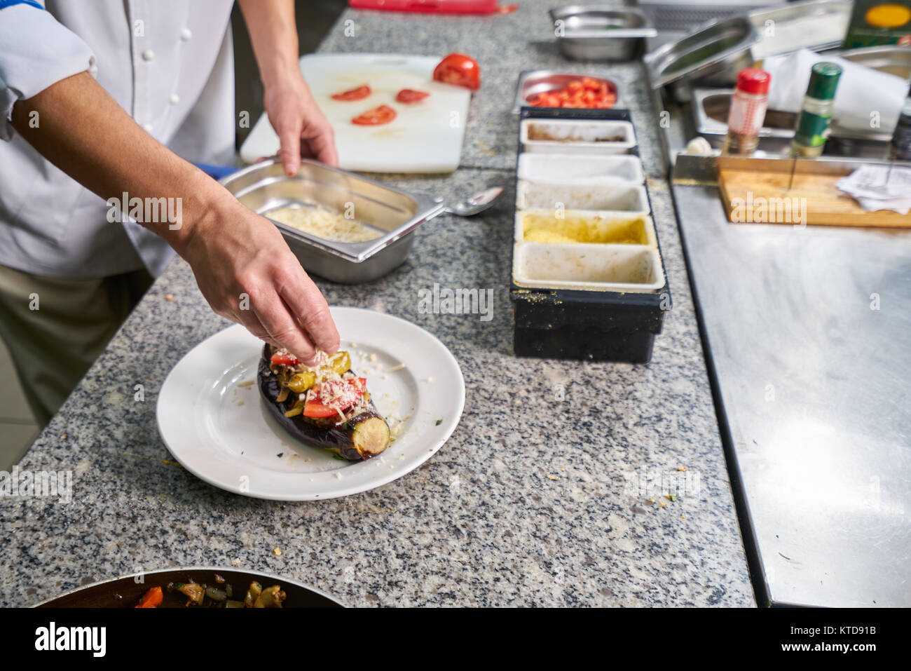 Chef sprinkling spices on dish in commercial kitchen Stock Photo - Alamy