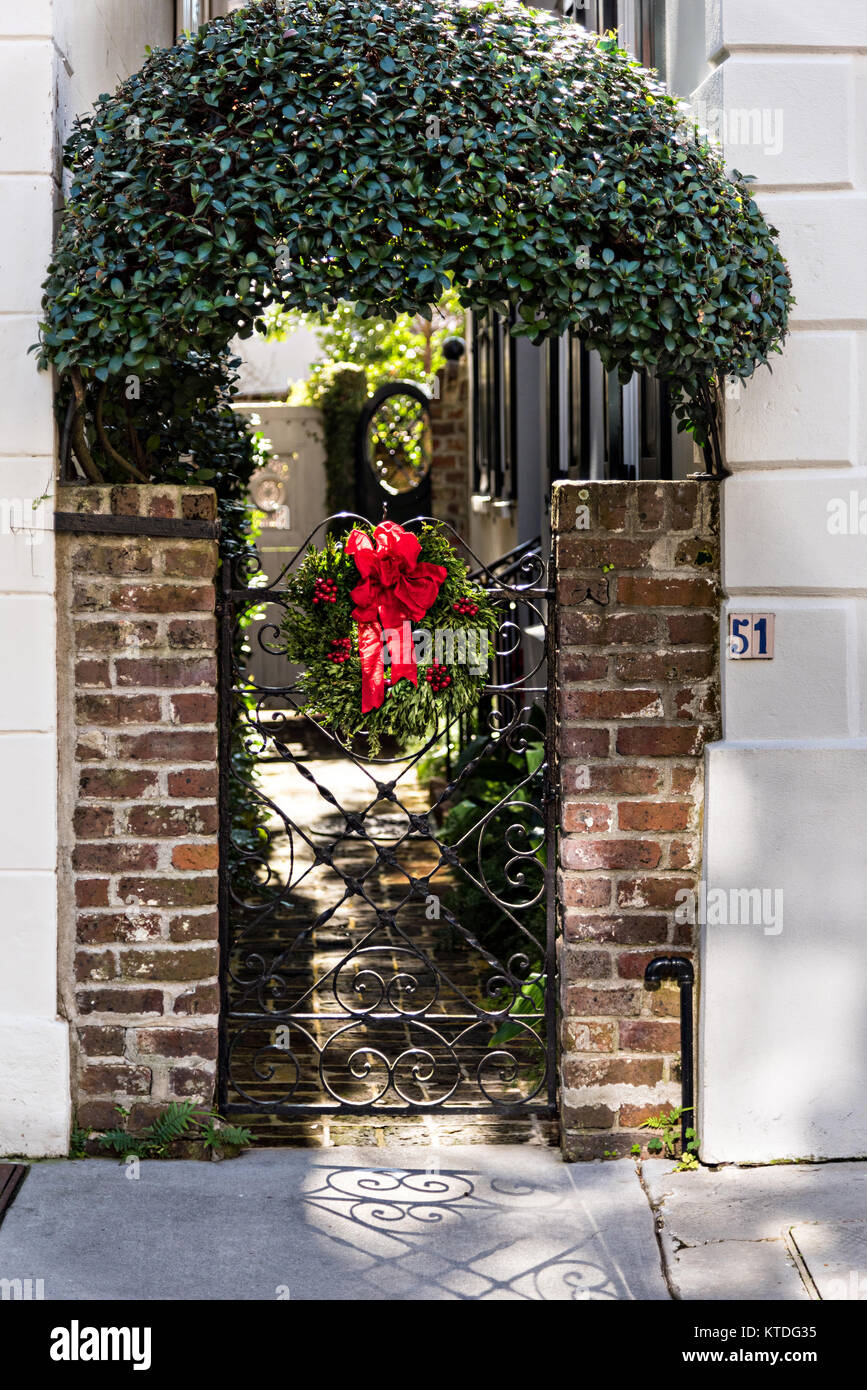 A wrought iron gate with a Christmas wreath at a historic home on Tradd ...