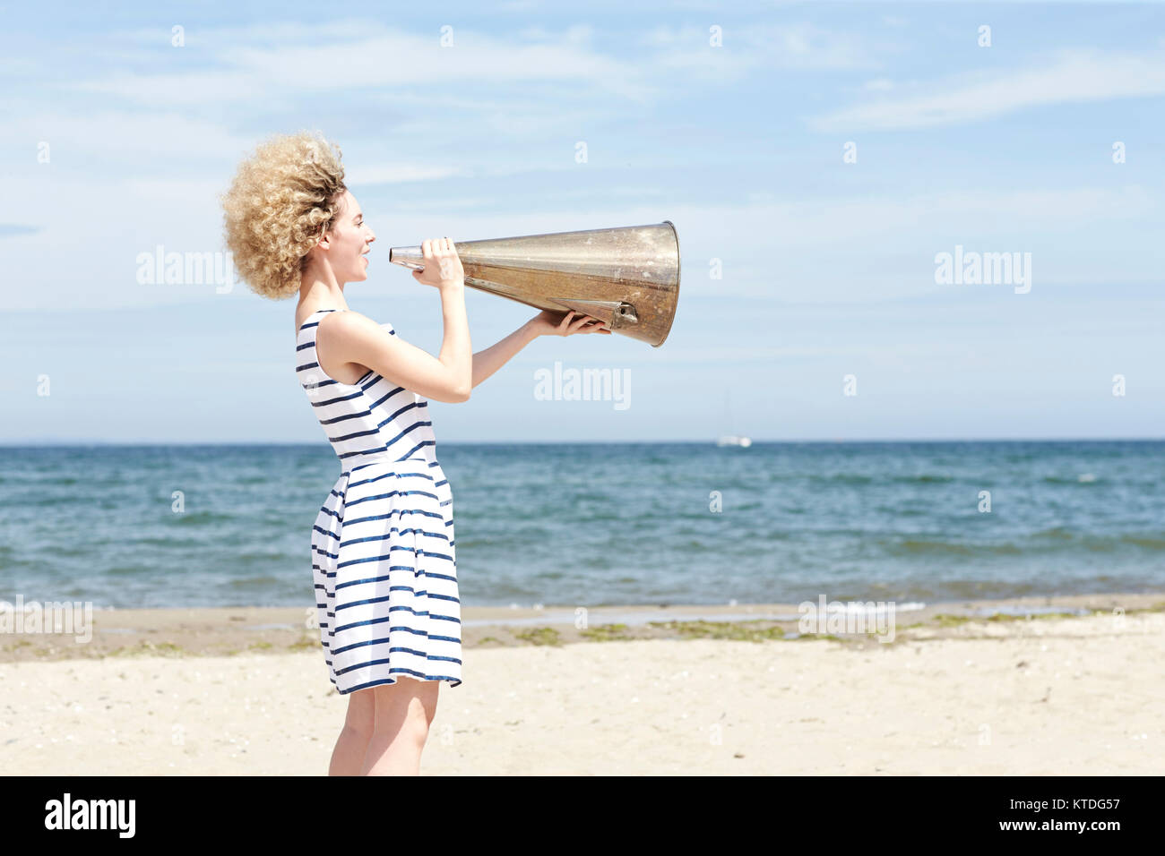 Young woman with megaphone on the beach Stock Photo - Alamy