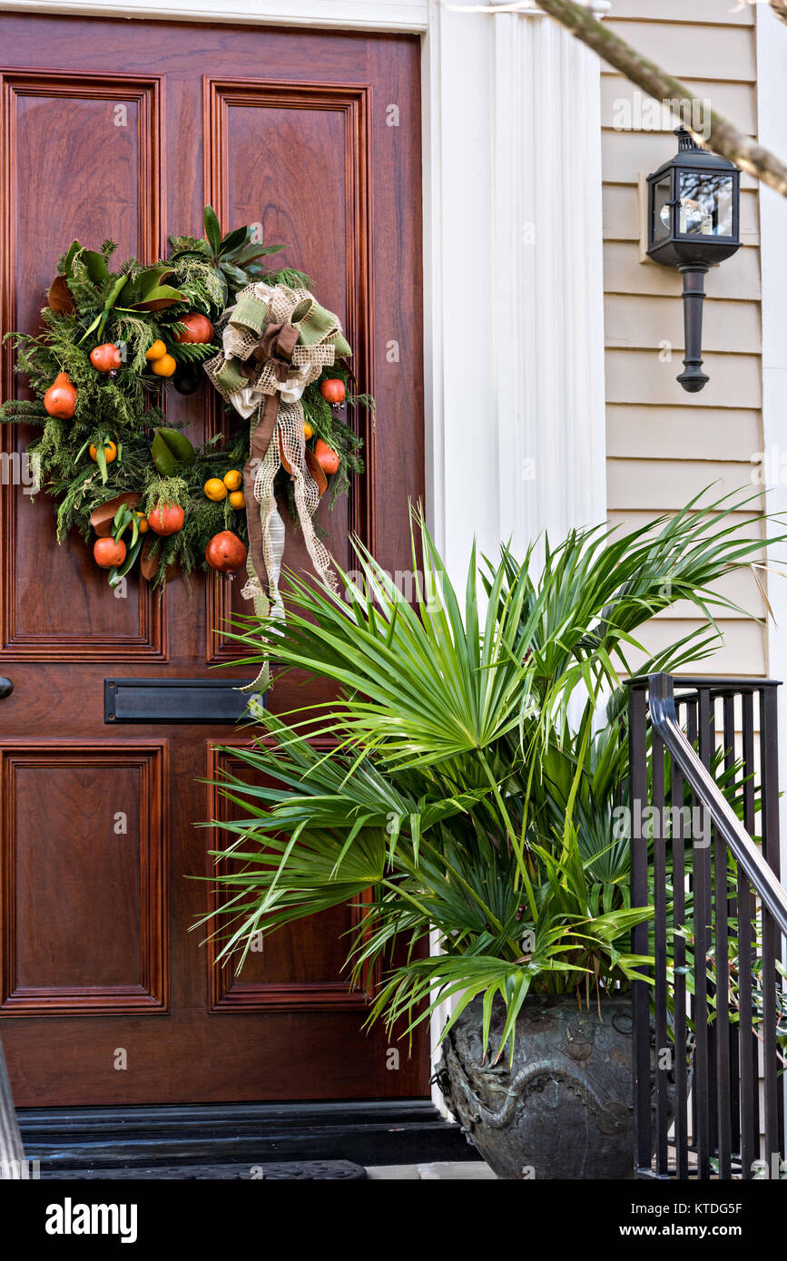 A traditional low country Christmas wreath decorated with fruit hangs ...