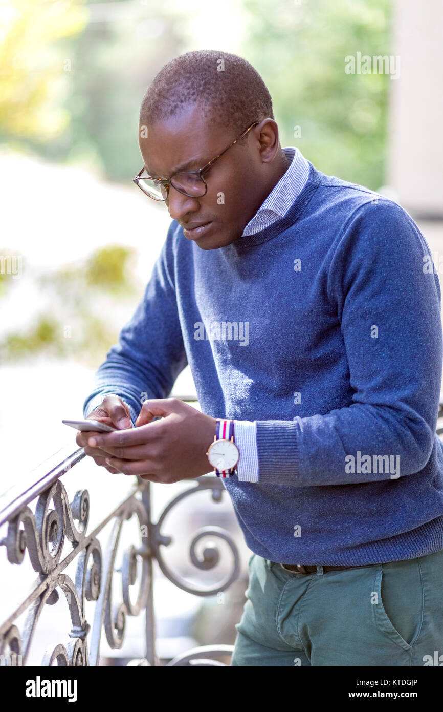 Man using cell phone on balcony Stock Photo - Alamy