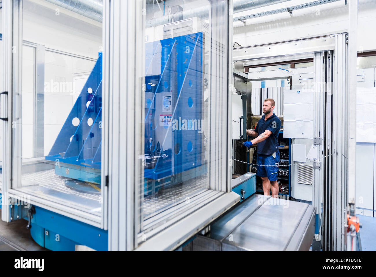 Man operating machine in industrial factory Stock Photo - Alamy