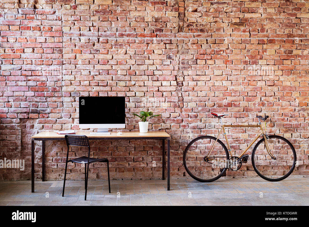 Workspace and bicycle at brick wall in office Stock Photo - Alamy
