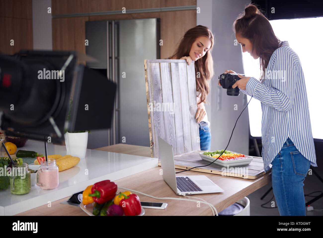Bloggers photographing food in kitchen Stock Photo - Alamy