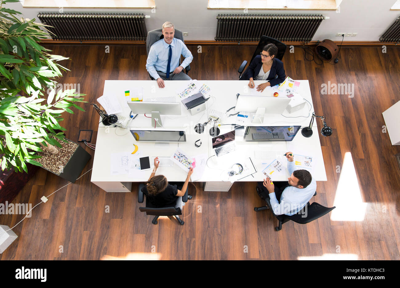 Business people in planning office sitting at desk, working together ...