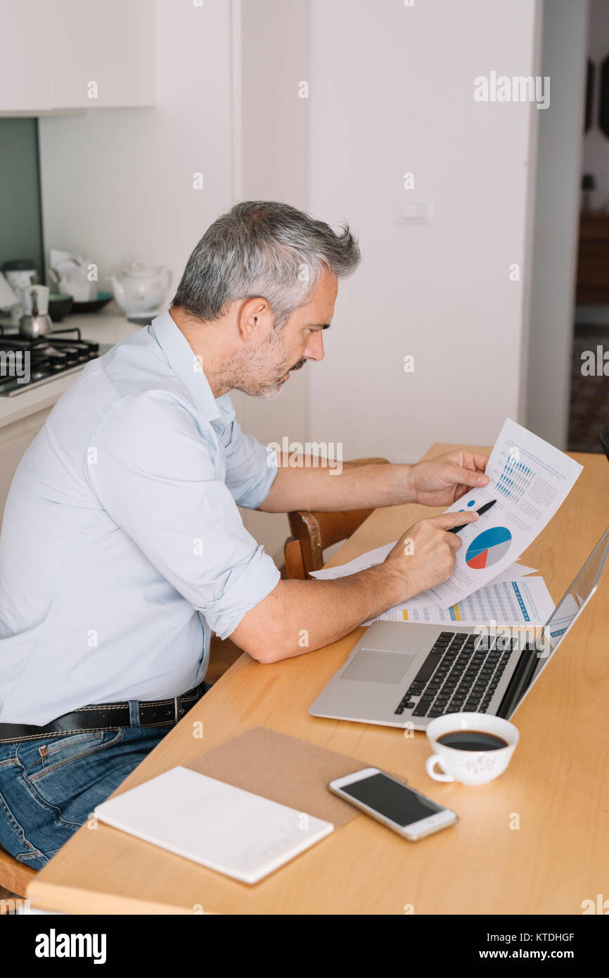 Man analysing data and using laptop in home office Stock Photo - Alamy