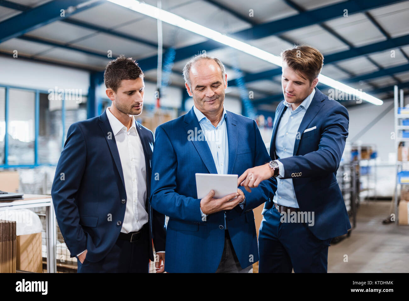Business people having a meeting in company shop floor Stock Photo - Alamy