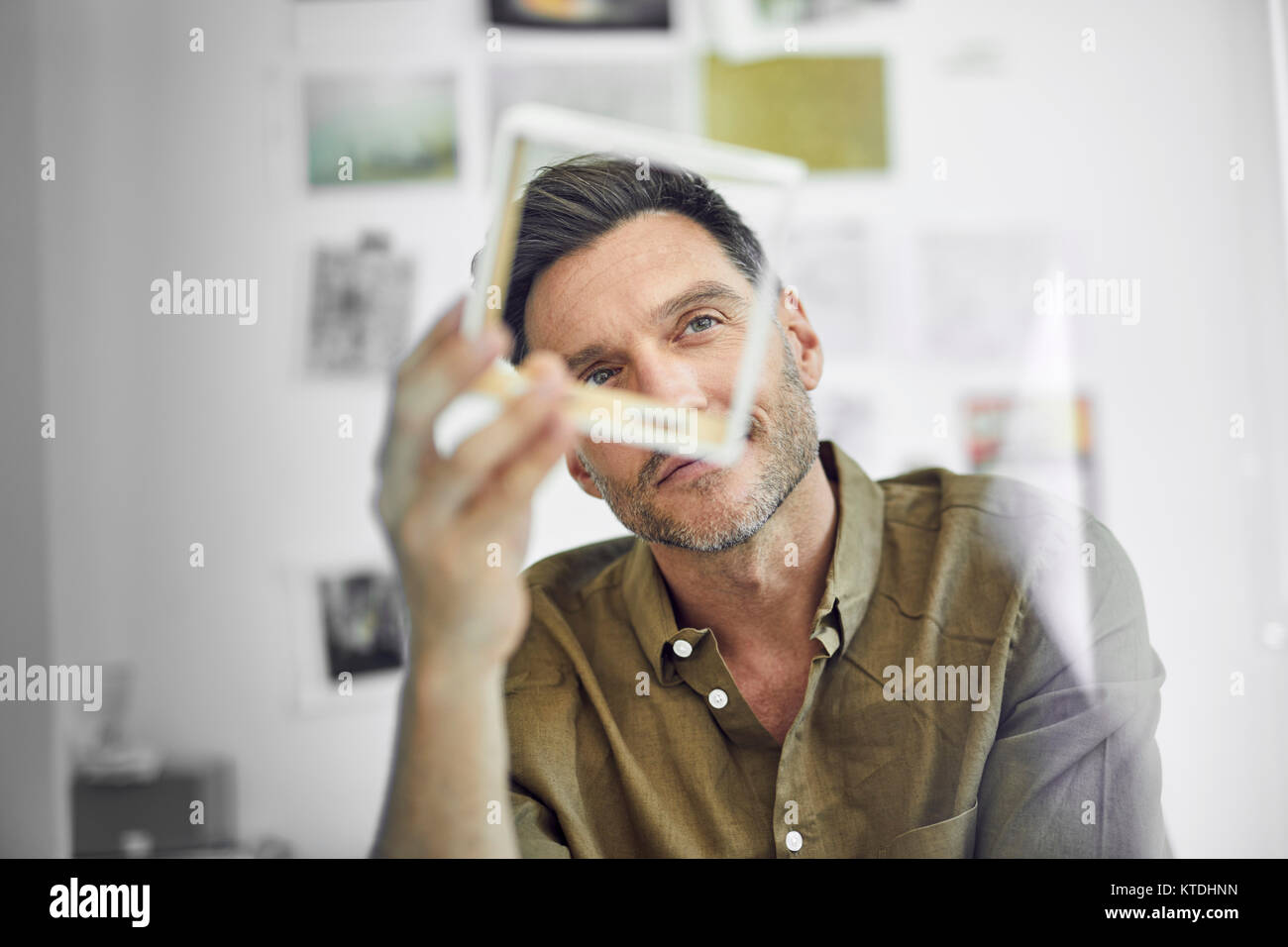 Portrait of man checking component in his office Stock Photo - Alamy