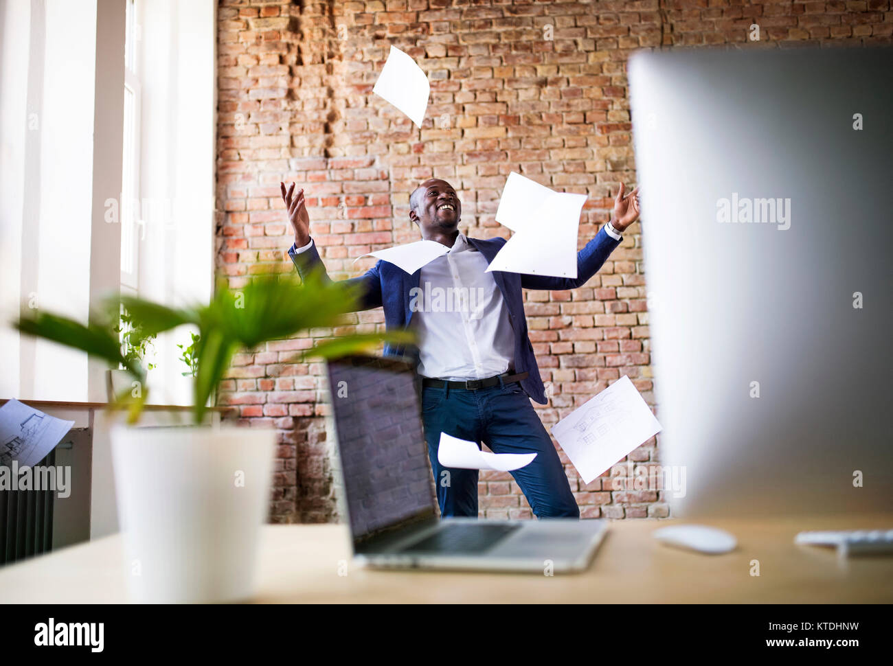 Carefree businessman in office throwing away papers Stock Photo - Alamy