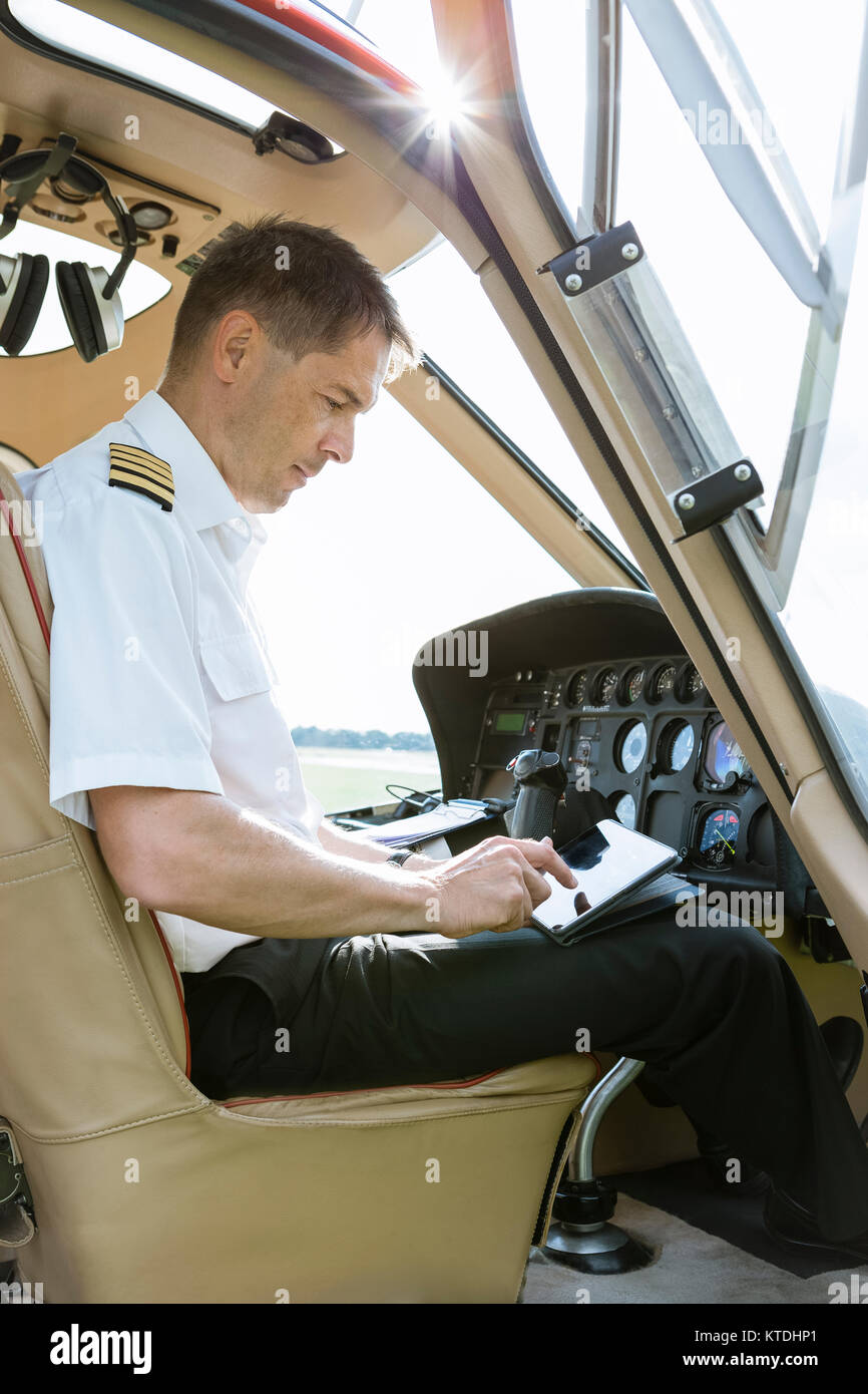 Pilot using tablet in cockpit of a helicopter Stock Photo - Alamy