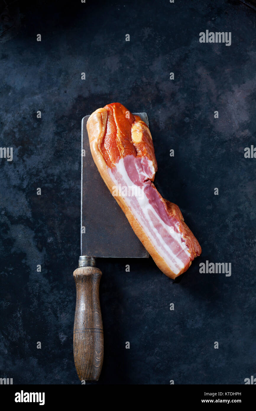 Streaky bacon with old cleaver on dark background Stock Photo - Alamy