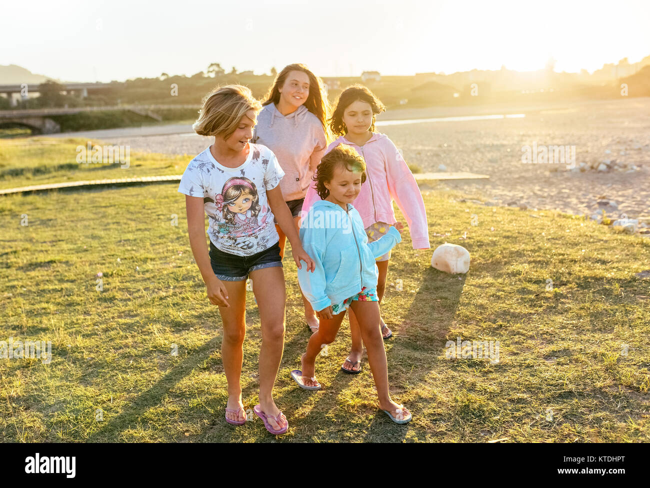 Four girls playing outdoors at sunset girls on boardwalk Stock Photo ...
