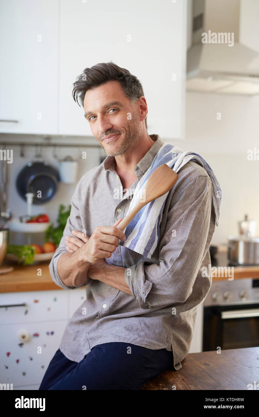 Portrait of smiling man with cooking spoon in the kitchen Stock Photo ...