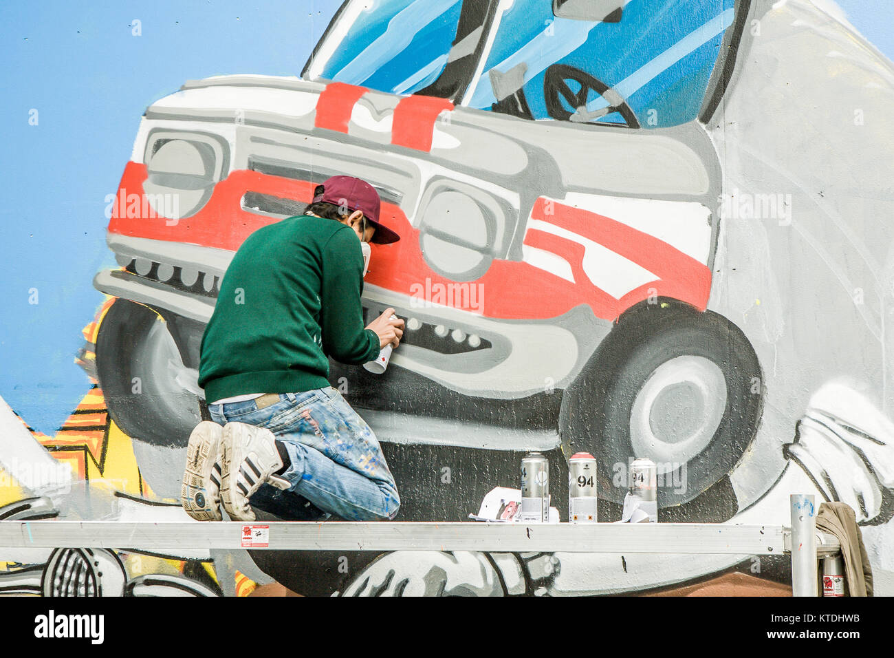 A street art artist is in the process of creating a graffiti wall piece ...