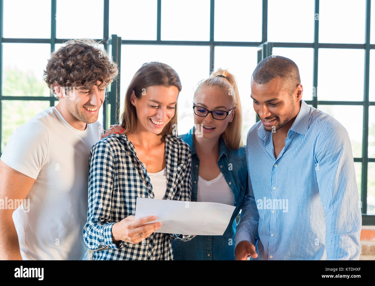 Young business people staning in office, reading businessplan for their ...