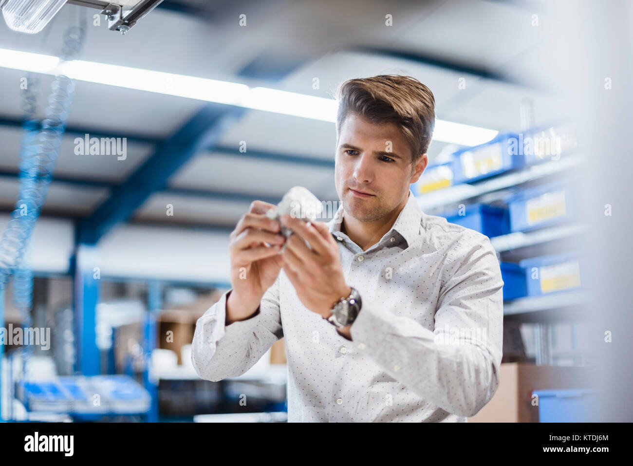 Businessman standing in shop floor, testing products Stock Photo - Alamy