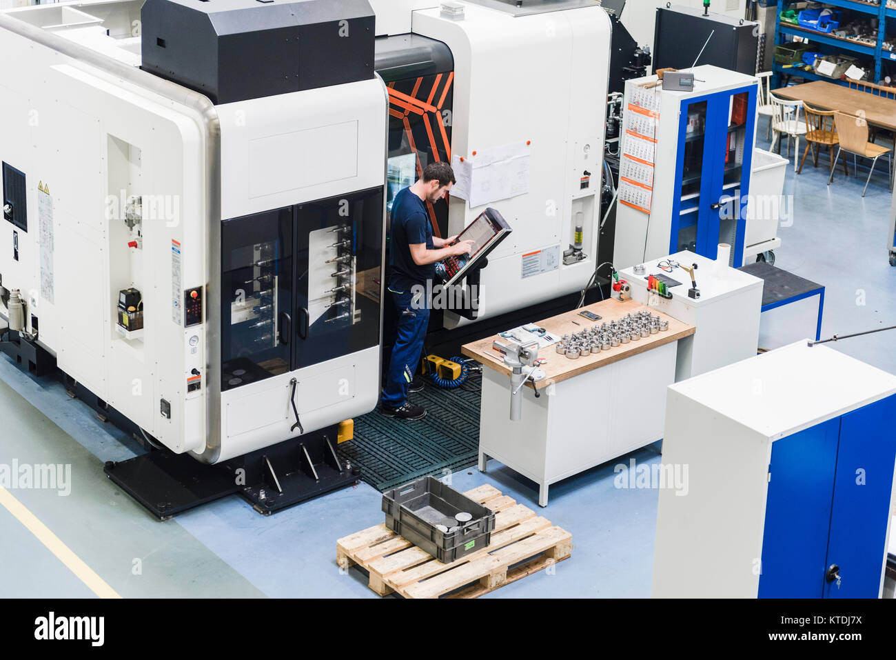 Man operating machine in industrial factory Stock Photo - Alamy