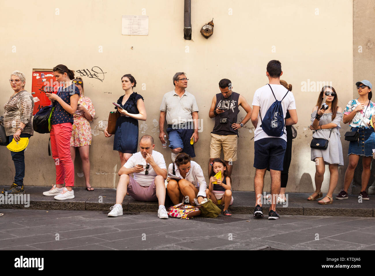 Tourists waiting in line outside the Accademia Gallery , Florence ...