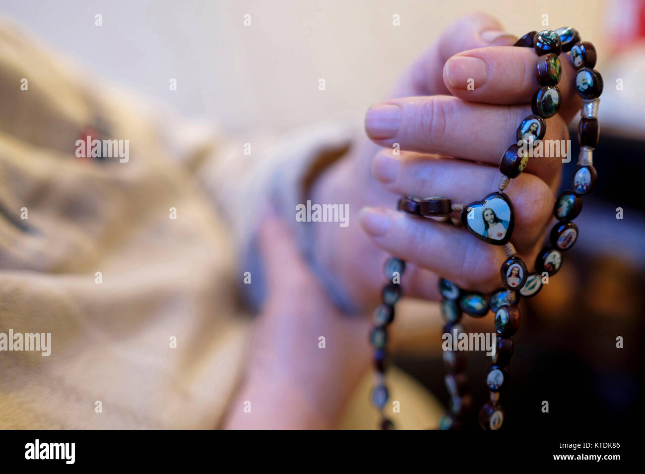 Woman holding hands up praying hi-res stock photography and images - Alamy