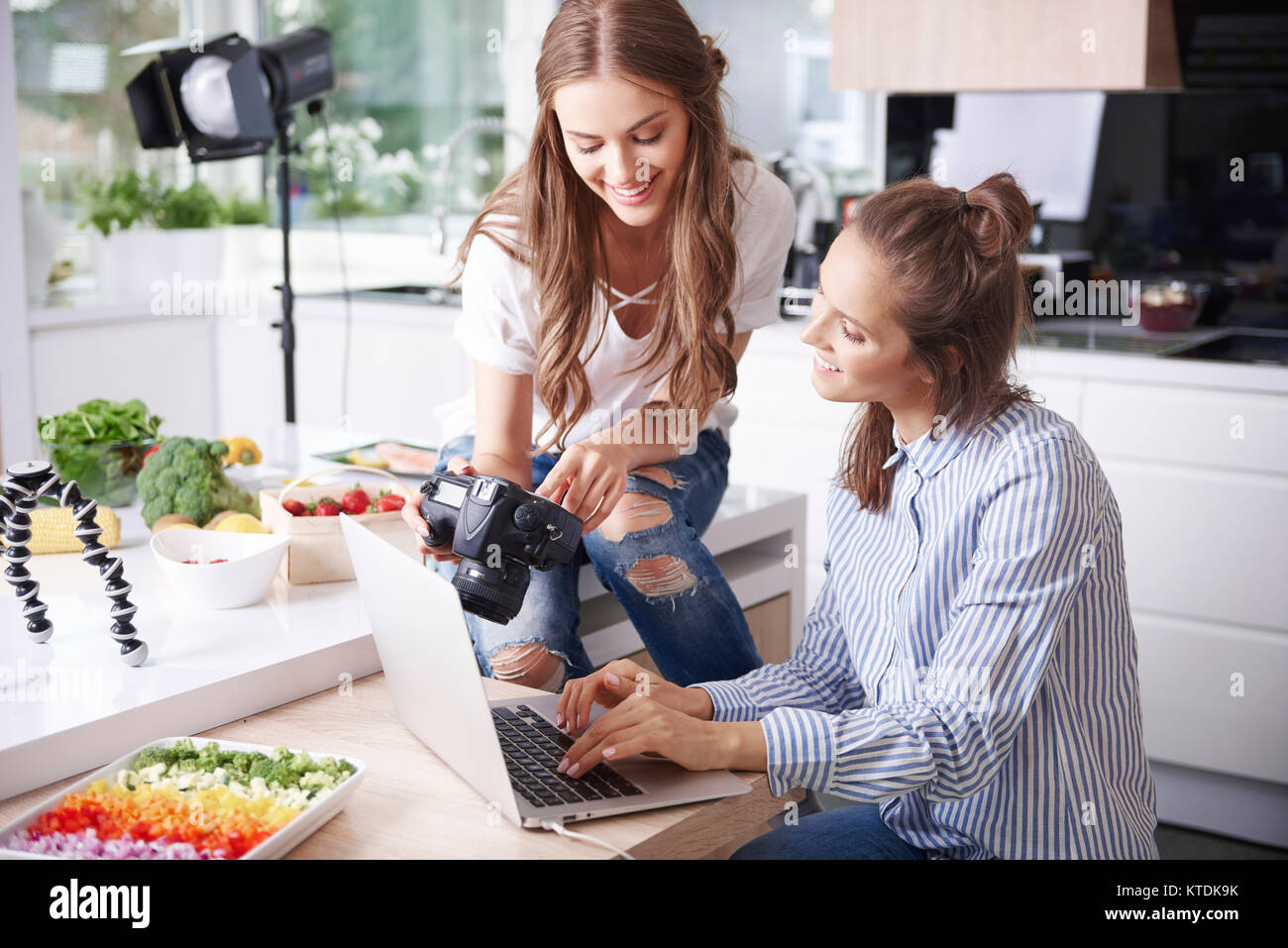 Two food bloggers choosing photos on digital camera Stock Photo - Alamy