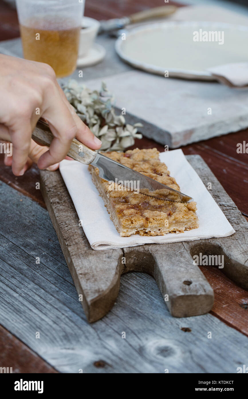 Italy, woman's hand cutting cake, partial view Stock Photo - Alamy